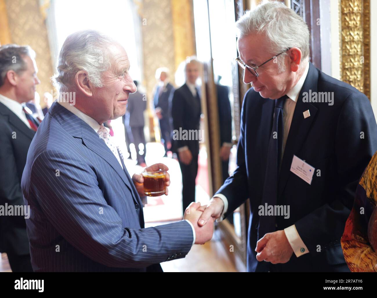 Britain's King Charles III shakes hands with Michael Gove during a ...