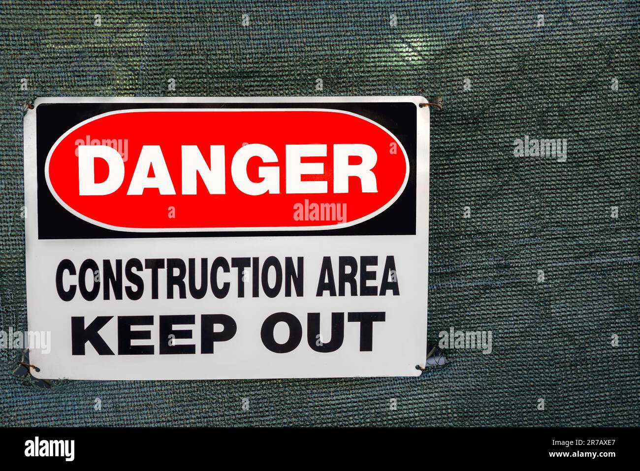 Close up of a keep out warning sign on a covered chain-link fence ...