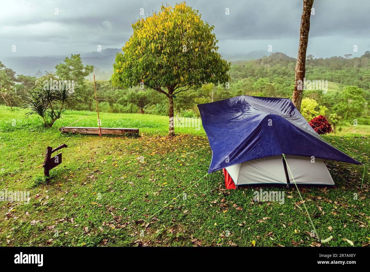 Camping activities in rain-filled holiday. Tent on campsite by the hill ...