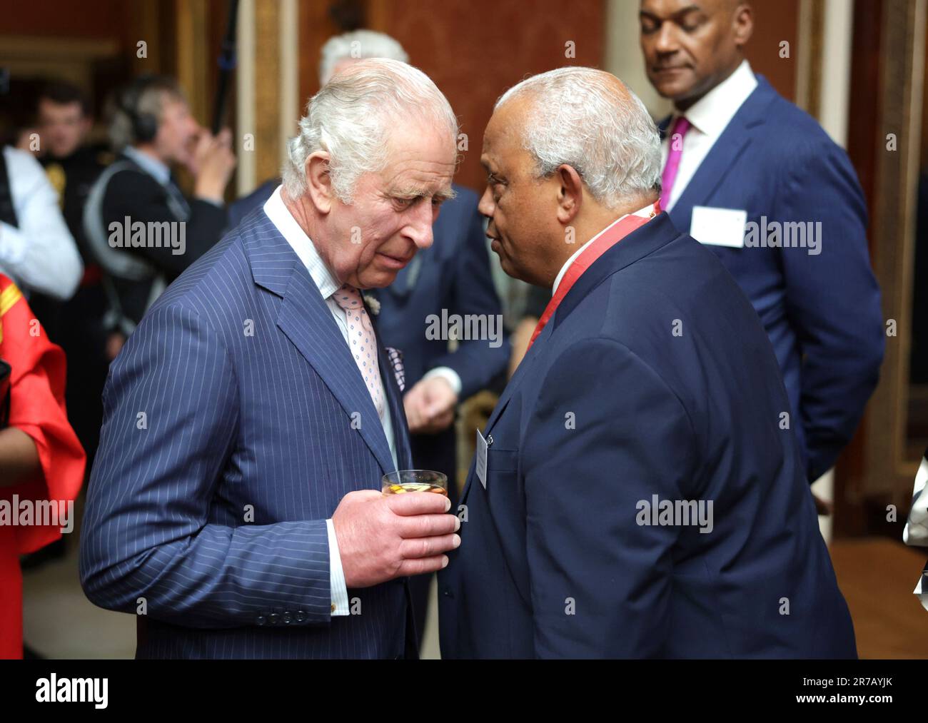 Britain's King Charles III, left, speaks with a guest during a ...
