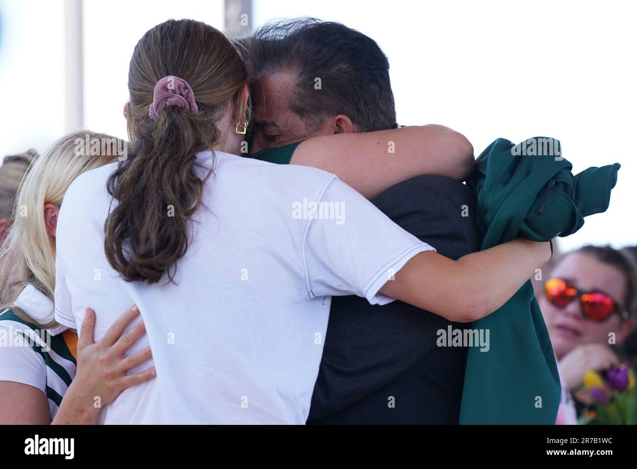 Grace O'Malley-Kumar's father is embraced by members of her hockey team ...
