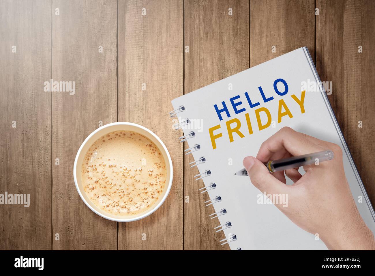 Coffee cup with human hand writing Hello Friday text on a notebook ...