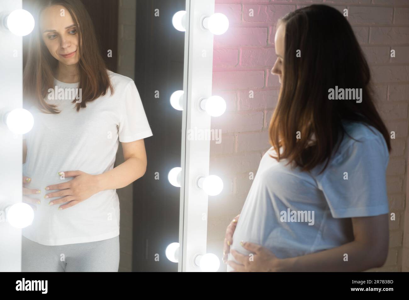 Pregnant woman with big belly in front of mirror, standing in room ...