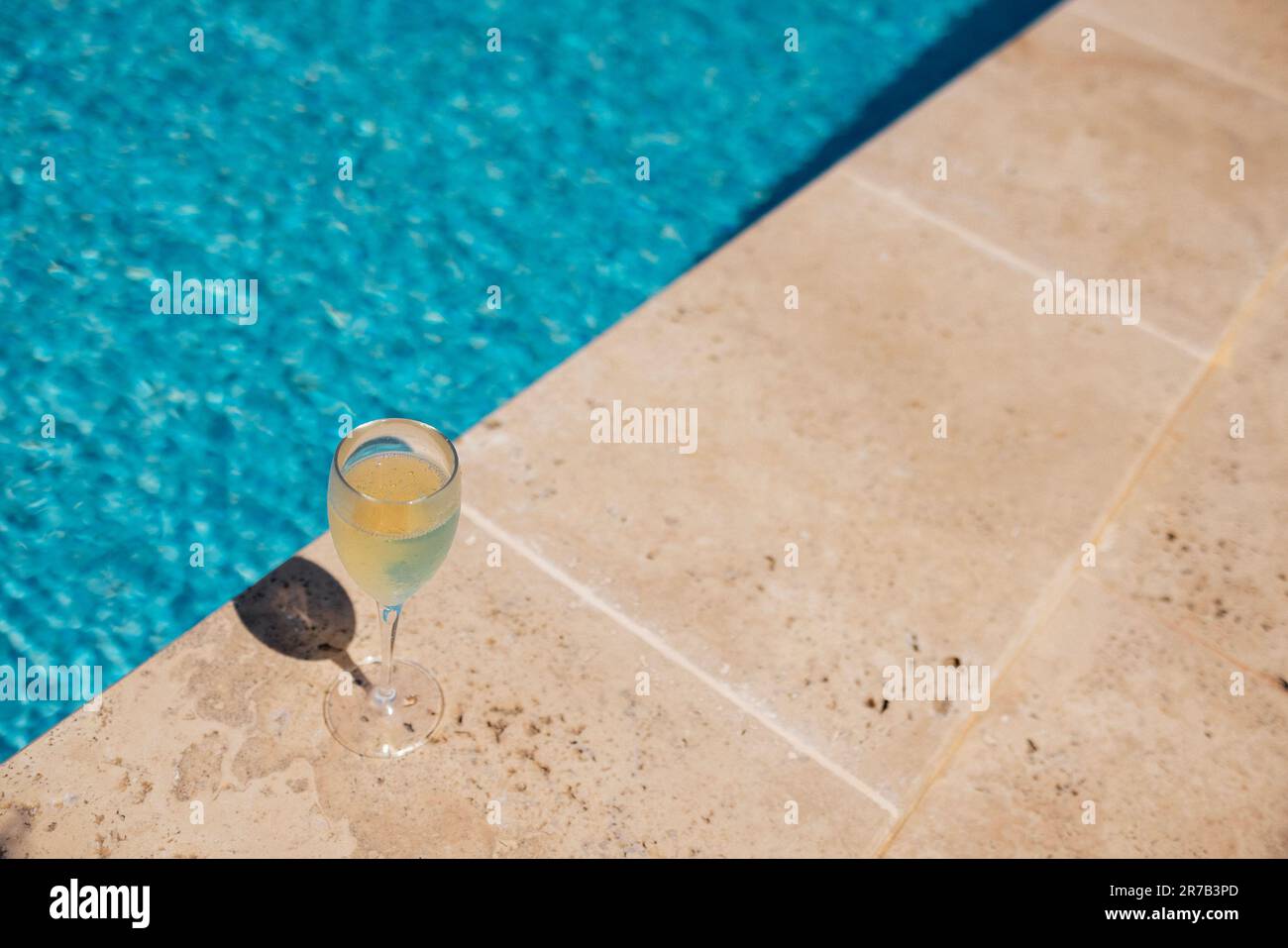 Cool glass of champagne against poolside at resort hotel during ...