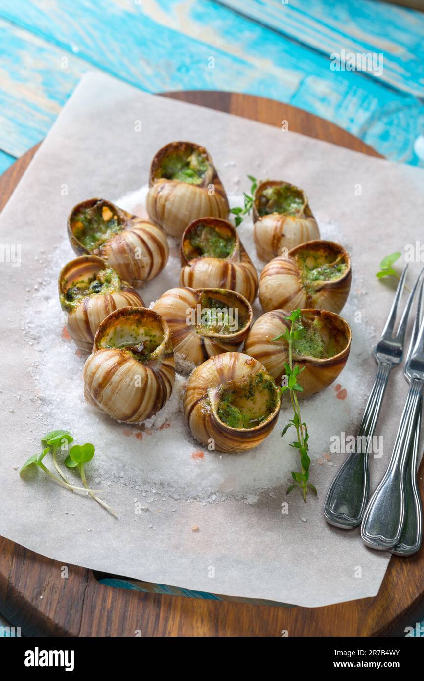 Baked snails with garlic butter and fresh herbs Stock Photo - Alamy
