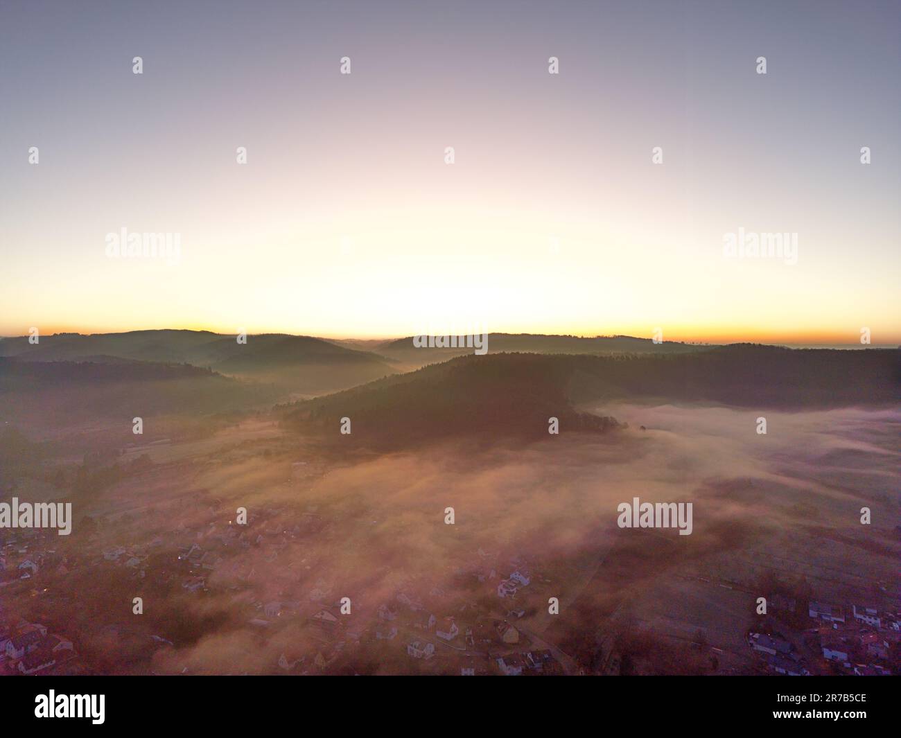 An aerial stunning view of a foggy sunset over Oberstenfeld, Germany ...