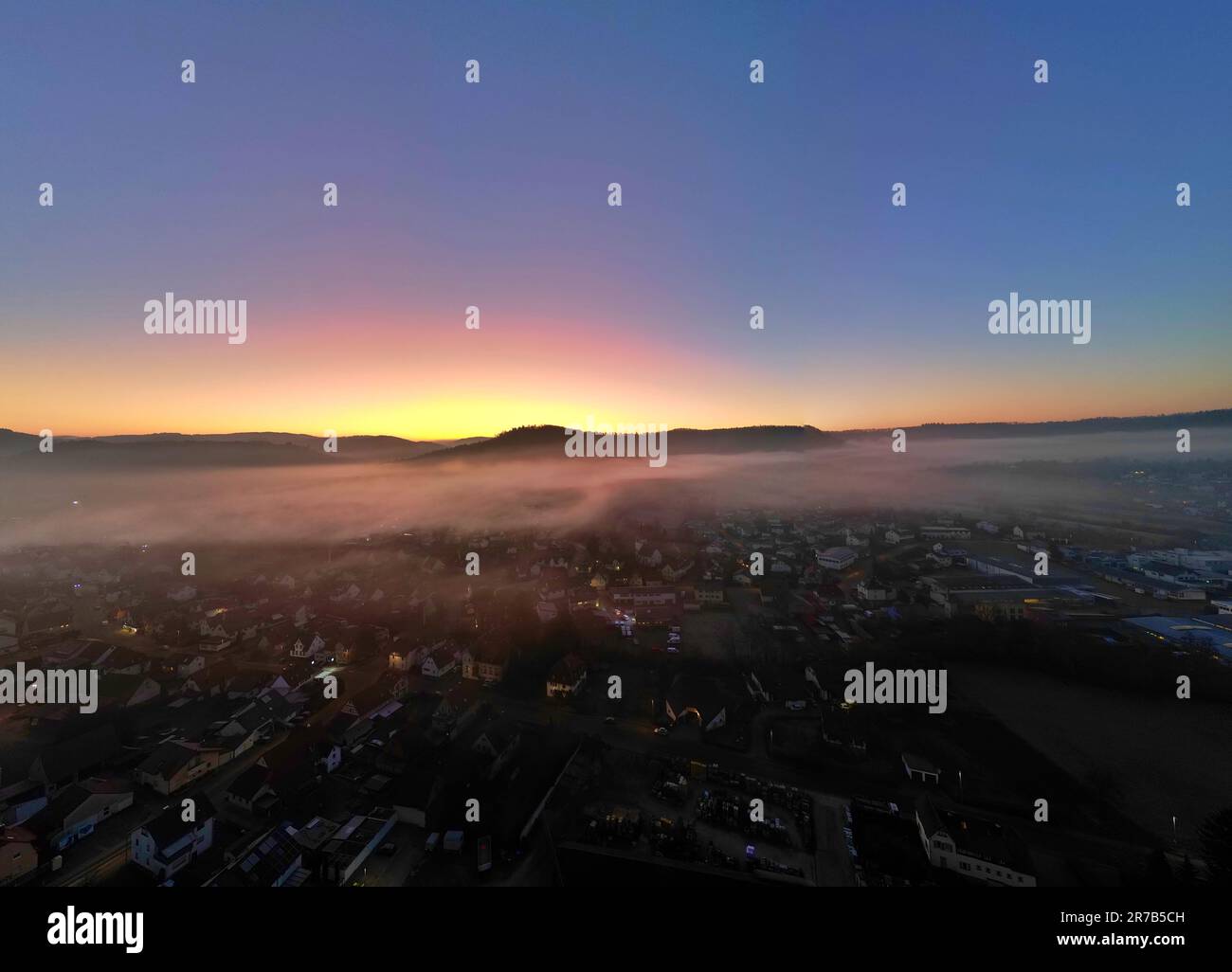 An aerial stunning view of a foggy sunset over Oberstenfeld, Germany ...