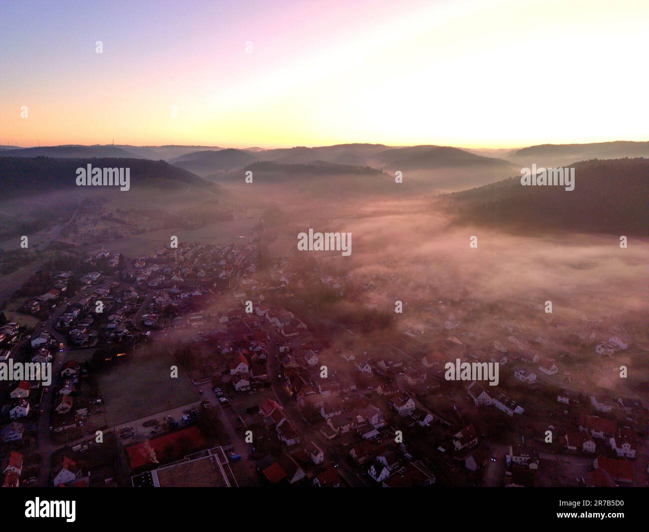An aerial stunning view of a foggy sunset over Oberstenfeld, Germany ...
