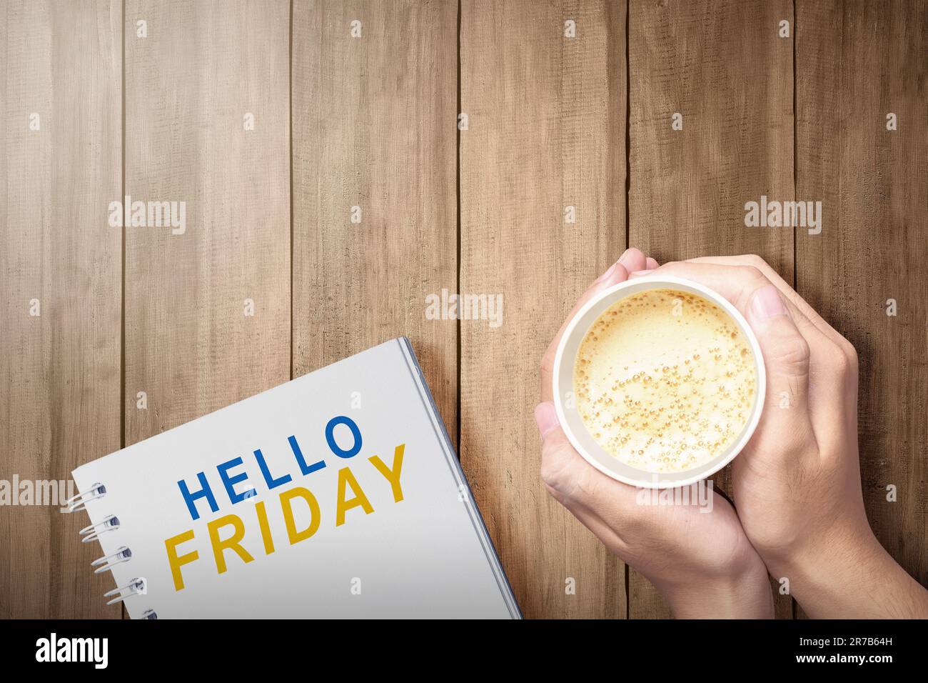 A human hand holding a coffee cup with a Hello Friday text. Happy ...