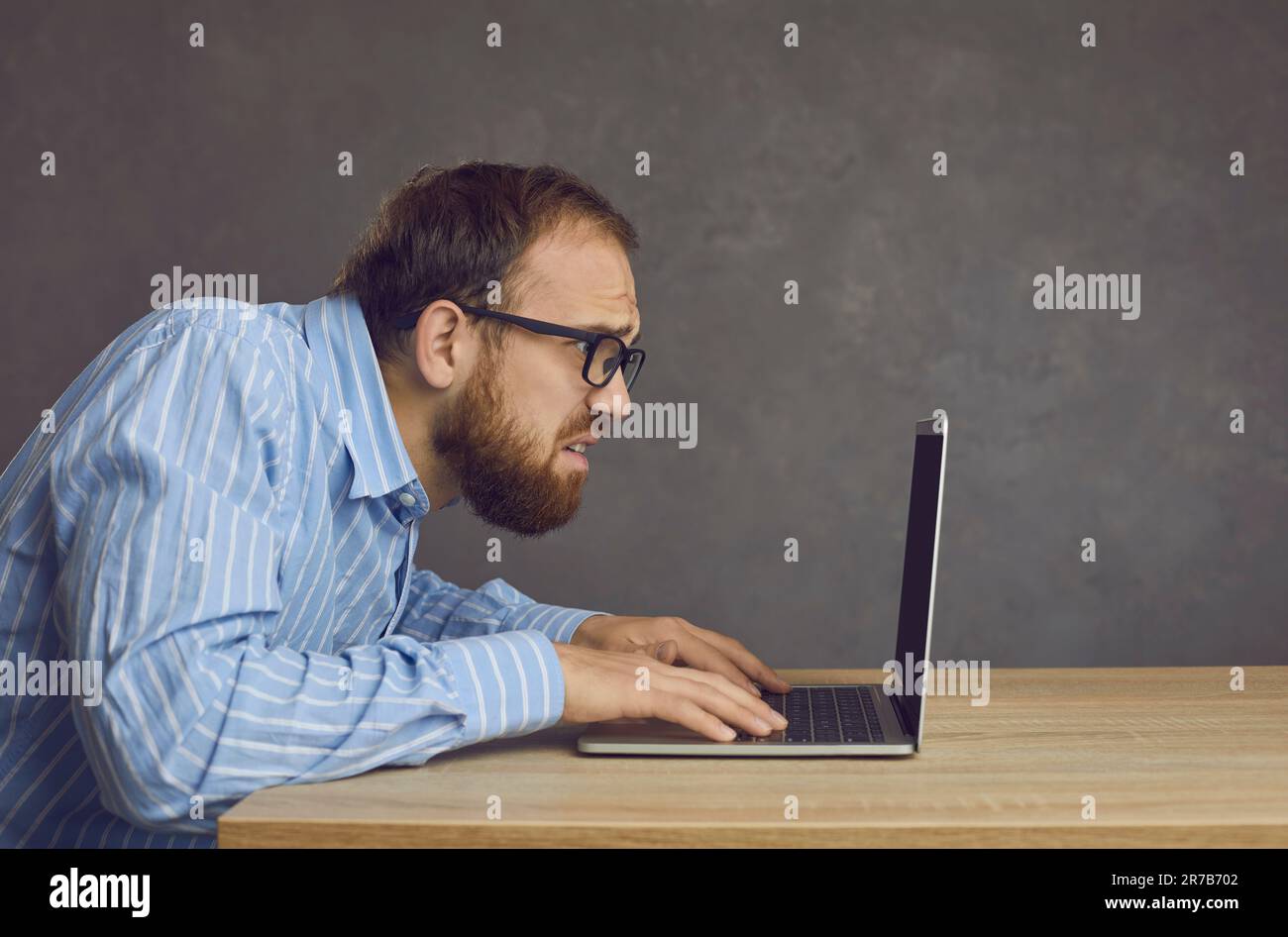 Frustrated middle aged Caucasian man annoyed typing on laptop keyboard ...