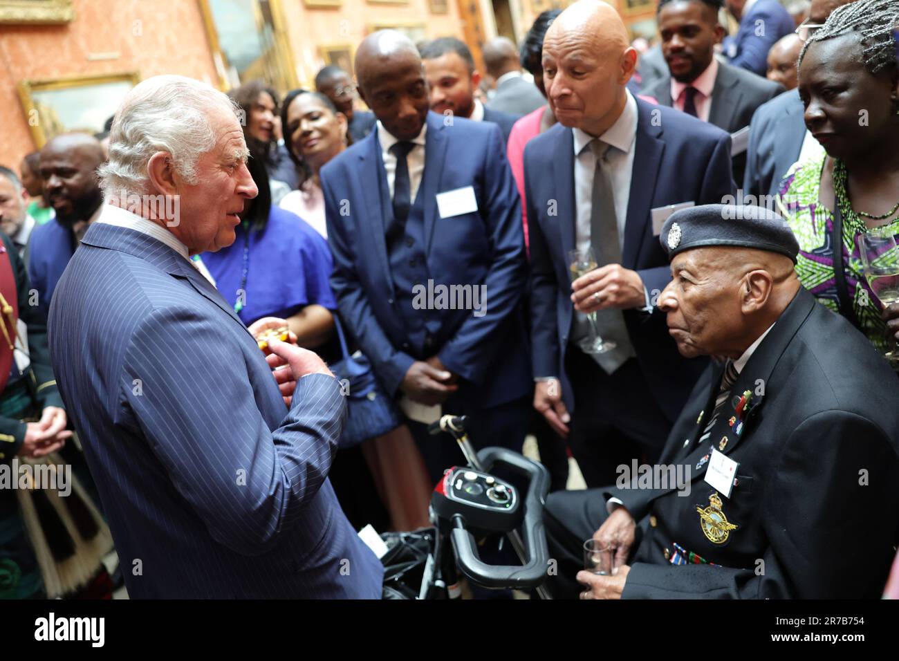 King Charles III speaks with a guest during a reception at Buckingham ...