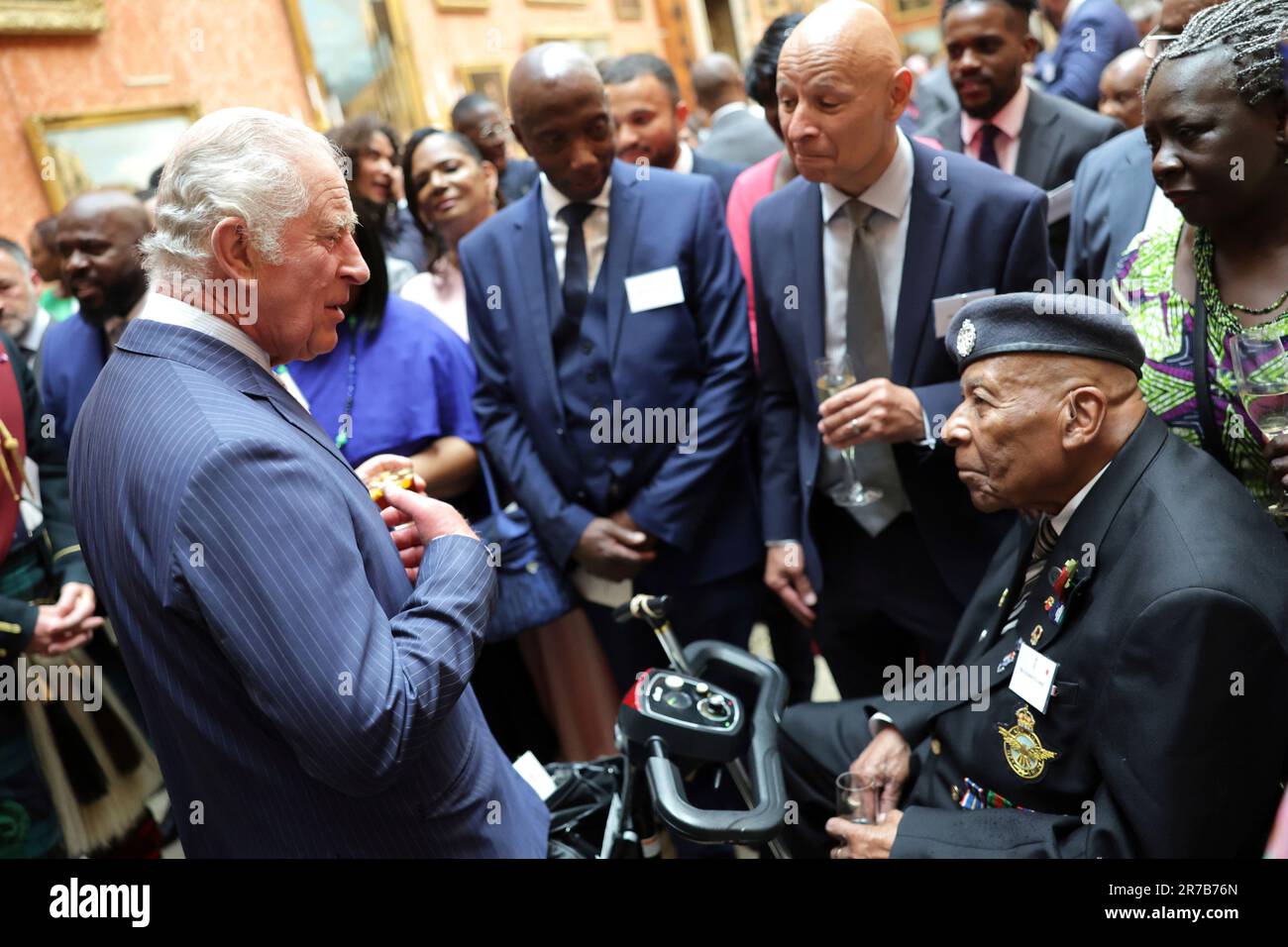 Britain's King Charles III, left, speaks with a guest during a ...
