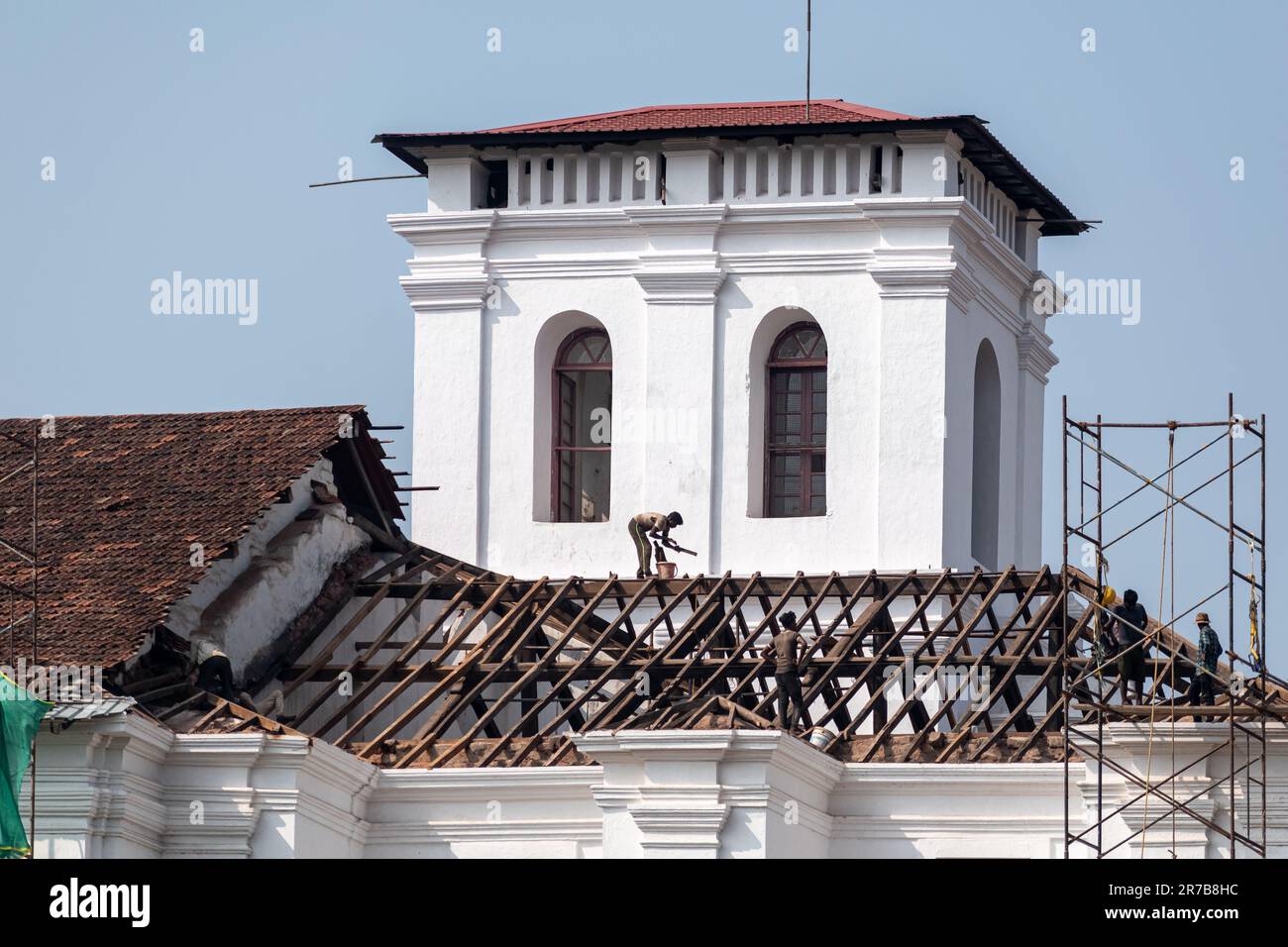 Old Goa, India - January 2023: Workers fixing the tiled roof of the ...