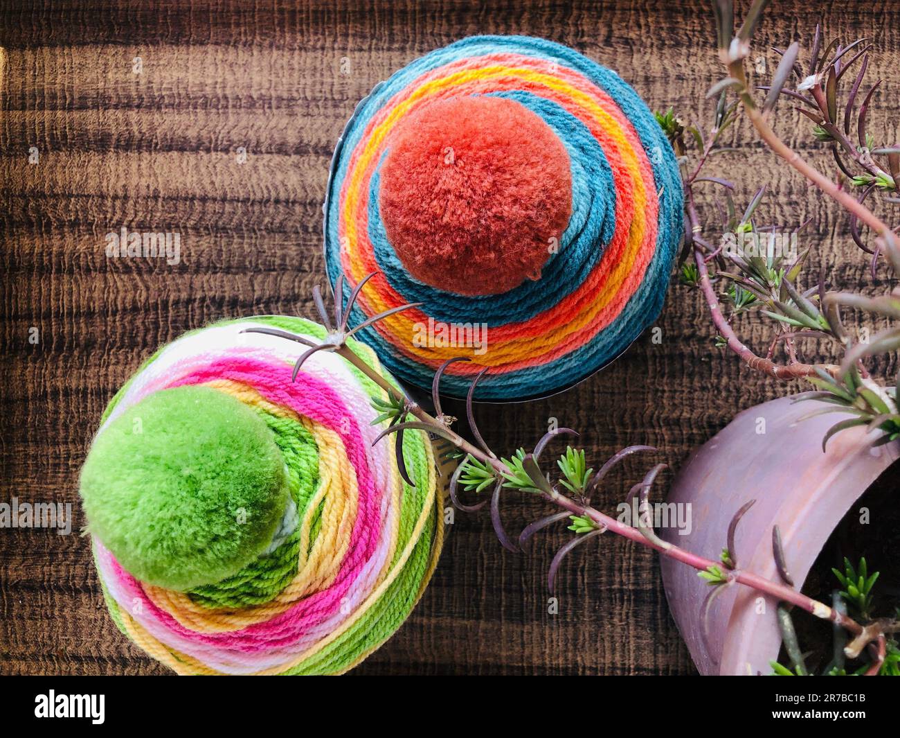 An assortment of vibrant colored yarn is creatively arranged beside a ...
