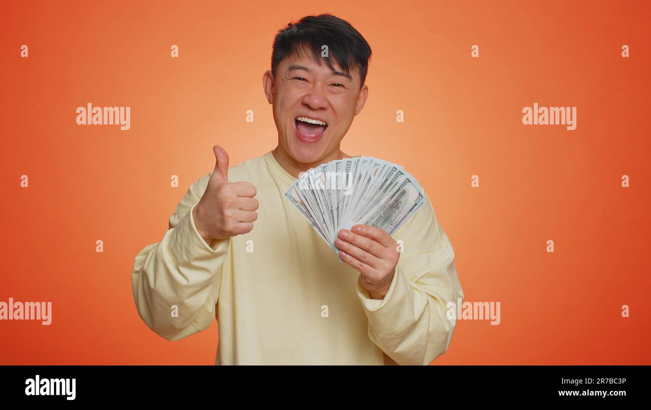Rich pleased boss chinese man waving money dollar cash banknotes bills ...