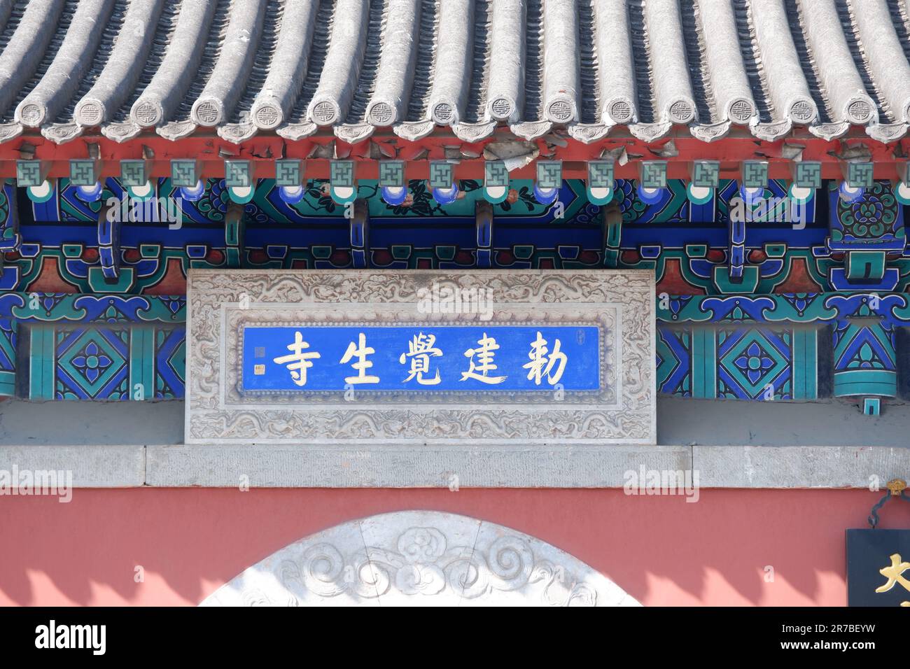 A signboard made of dark wood with Chinese characters is situated at ...