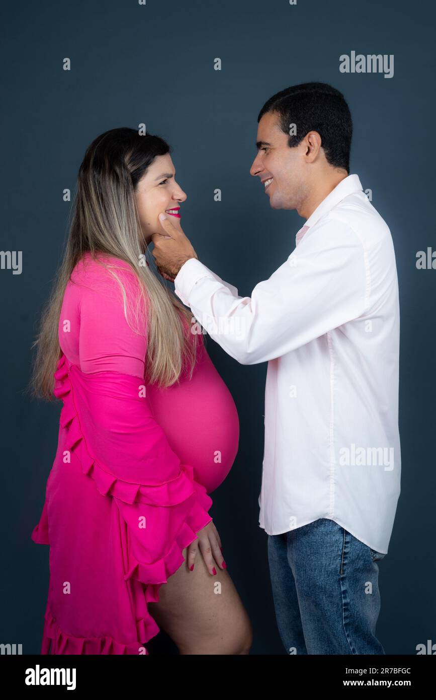 A loving couple, both with visible baby bumps, embrace each other ...