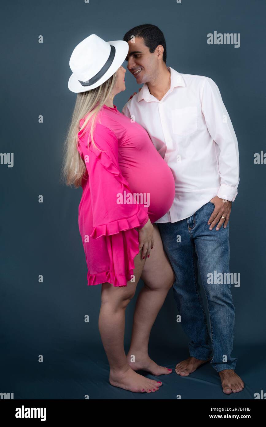 A loving couple, both with visible baby bumps, embrace each other ...