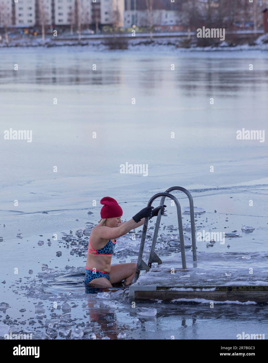 An adventurous woman is gearing up to take a dip in a frozen lake in ...