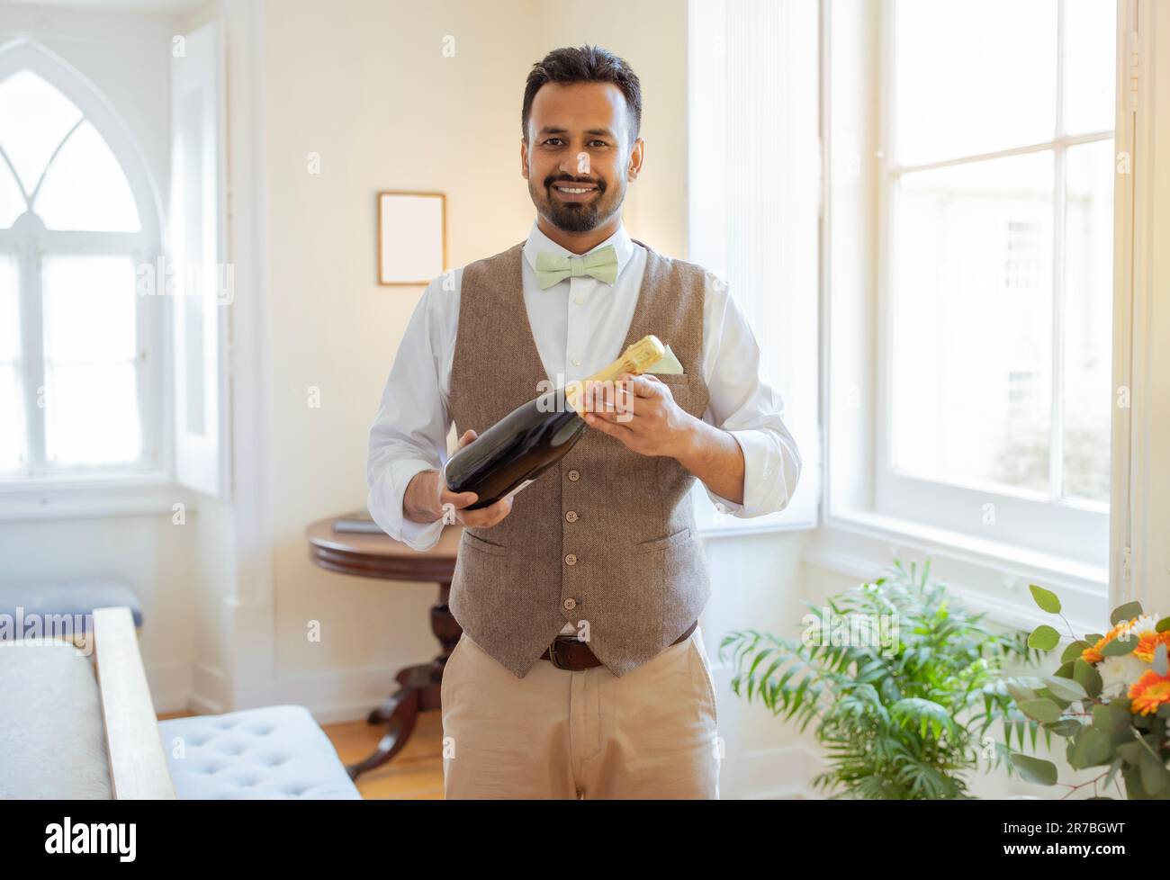 Indian Waiter Guy With Bottle Of Wine Standing At Hotel Stock Photo - Alamy