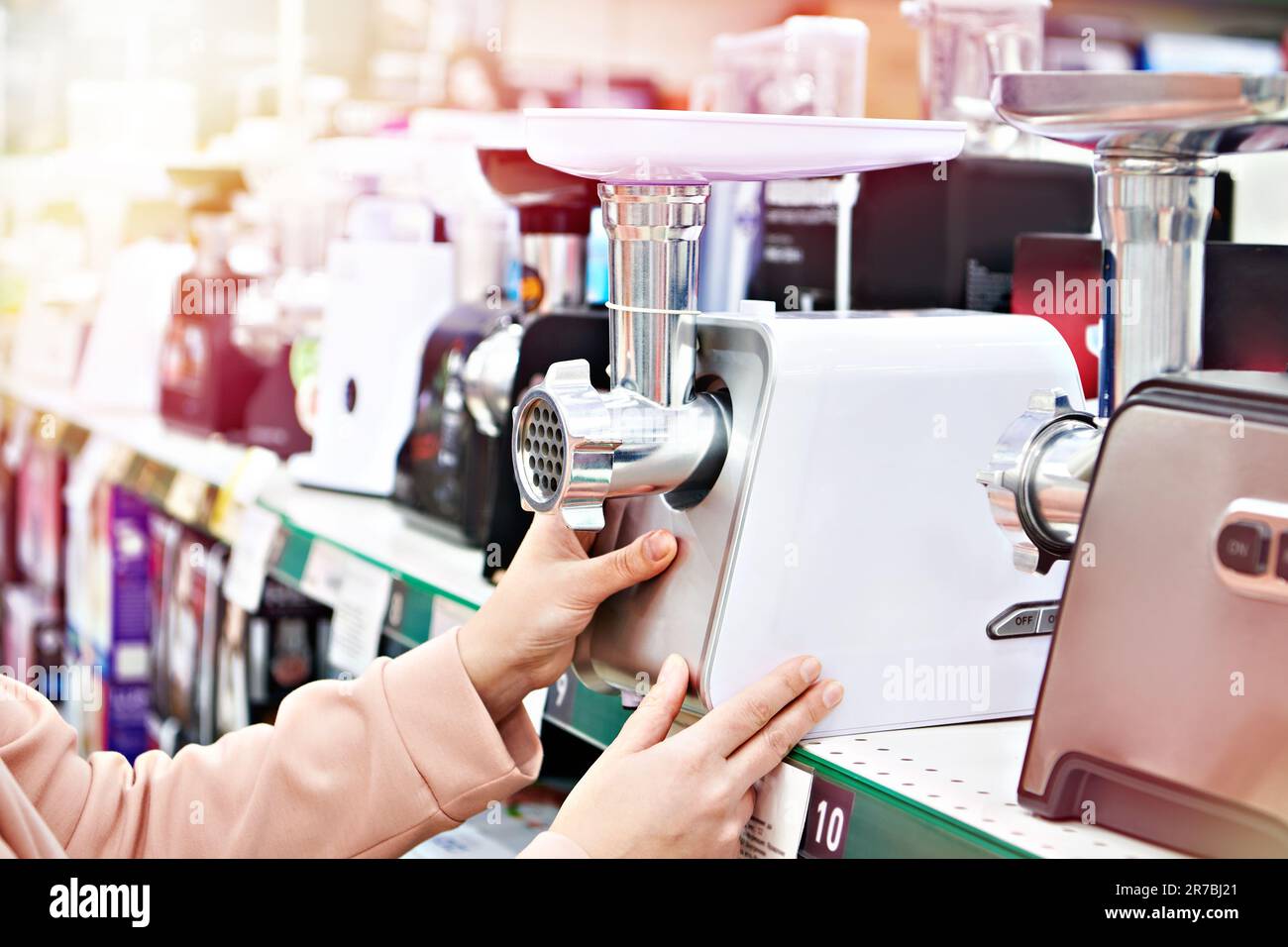 Electric meat grinder in the buyer hand in the store Stock Photo - Alamy
