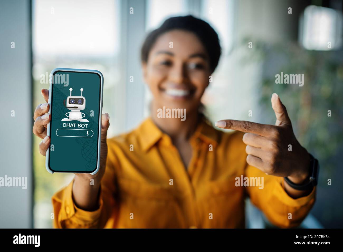 Phone with chat bot on screen in african woman hand Stock Photo - Alamy