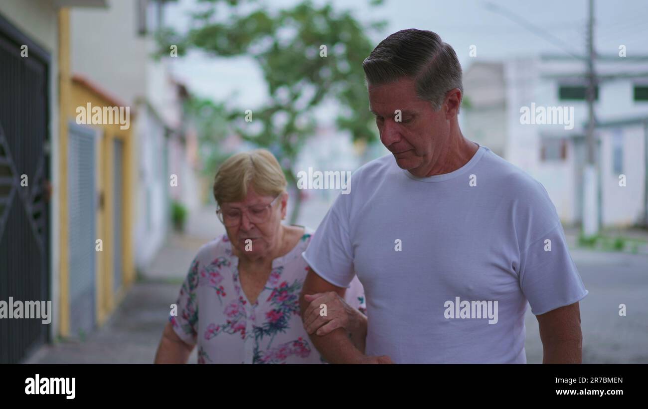 Elderly Mother Assisted by Middle-Aged Son in Walking, Supportive Care ...