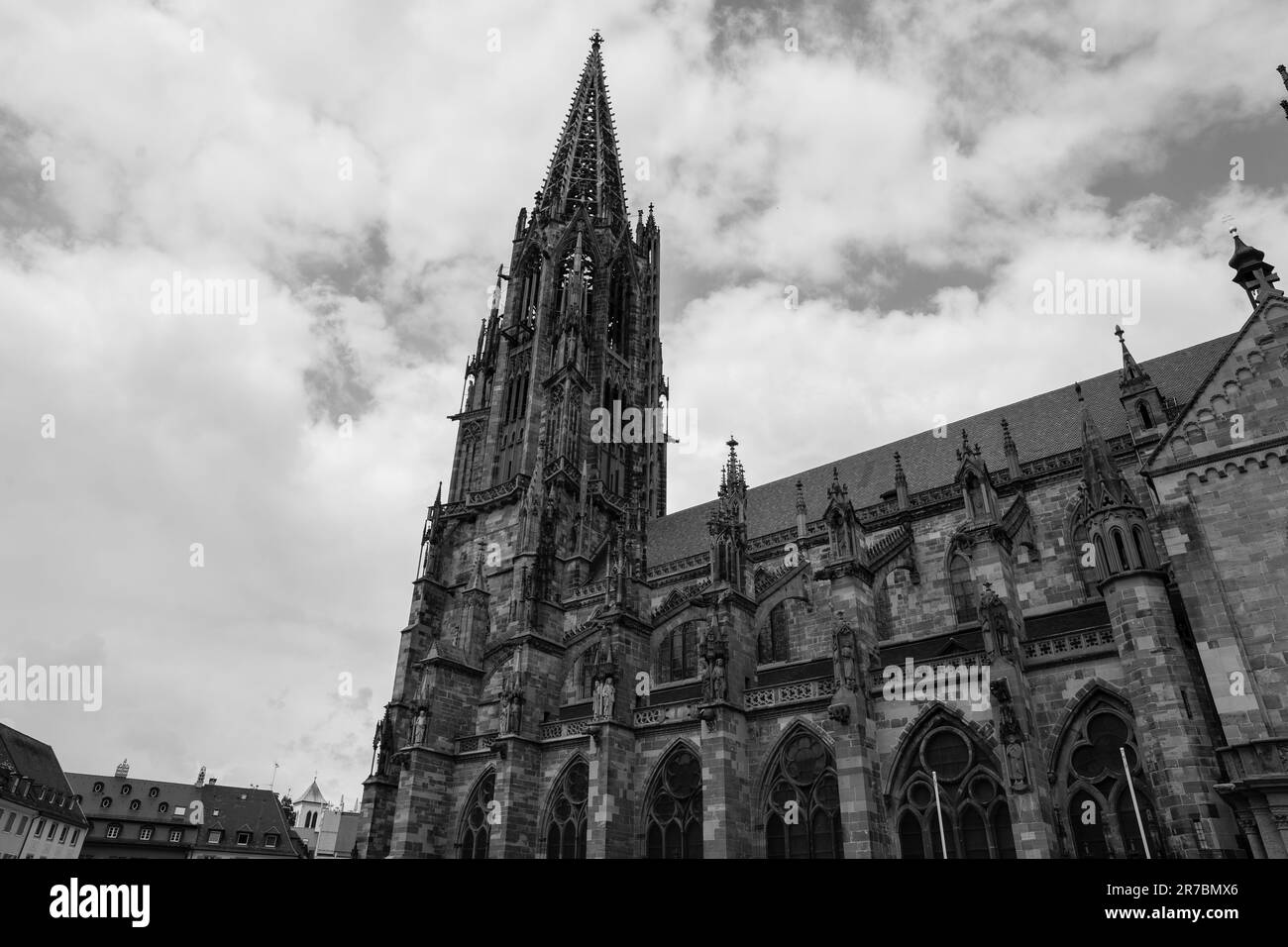 A majestic church spire stands tall amongst neighboring buildings ...