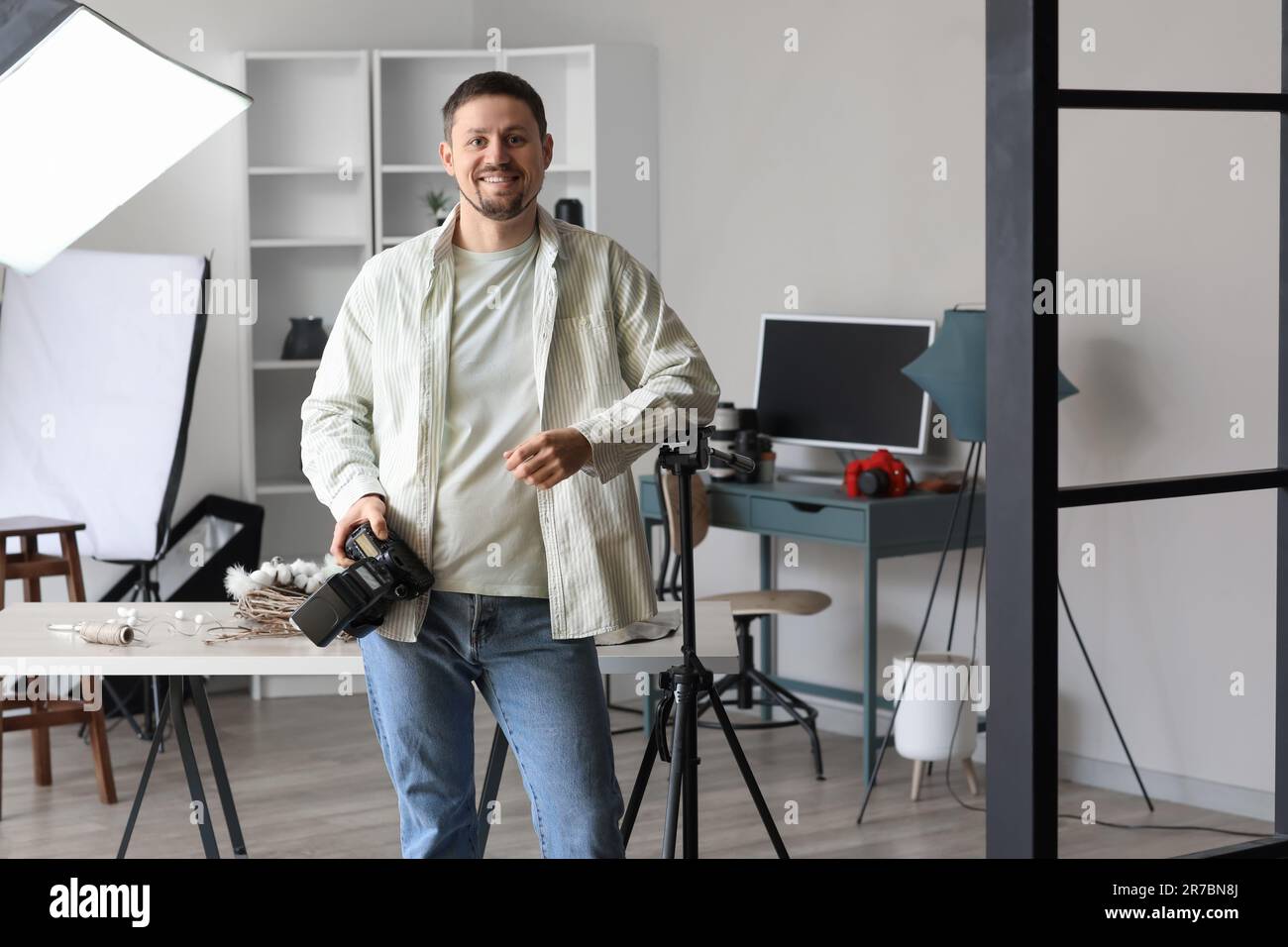 Handsome photographer with professional camera in studio Stock Photo ...
