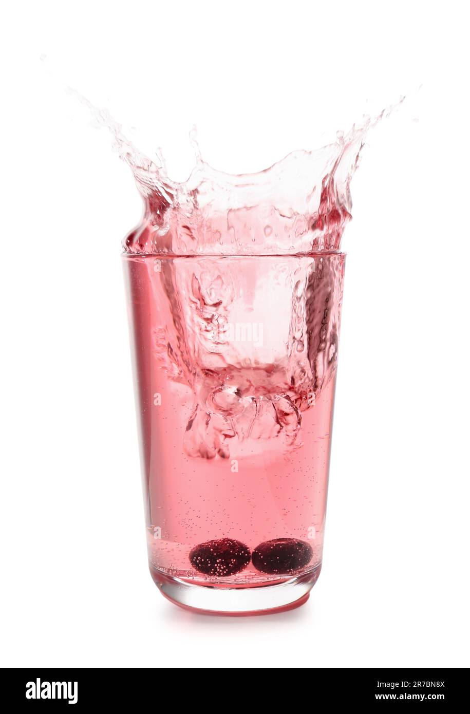 Glass of tasty blueberry cider with splashes, ice cube and berries ...