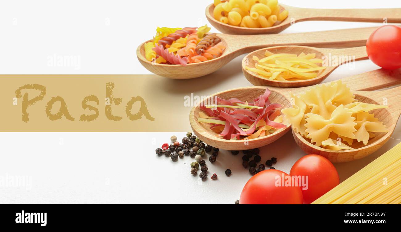 Spoons with different types of raw pasta, tomatoes and spice on white ...
