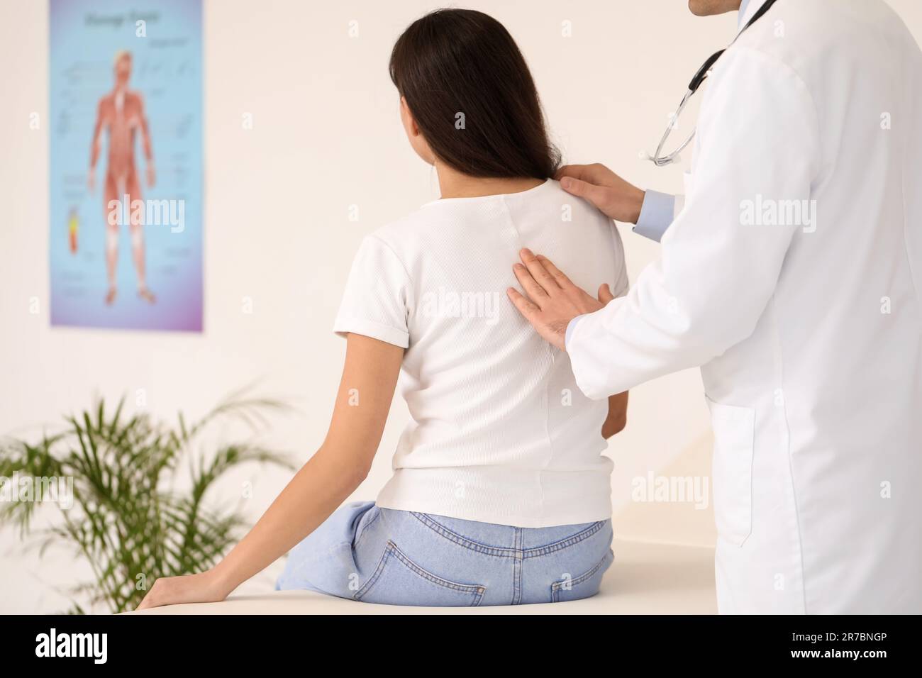 Male doctor checking posture of young woman in clinic Stock Photo - Alamy