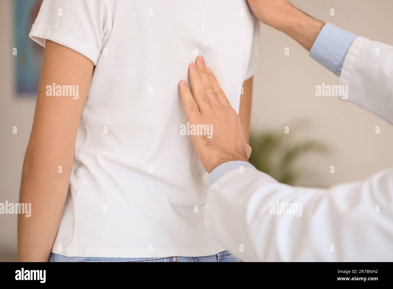Male doctor checking posture of young woman in clinic, closeup Stock ...