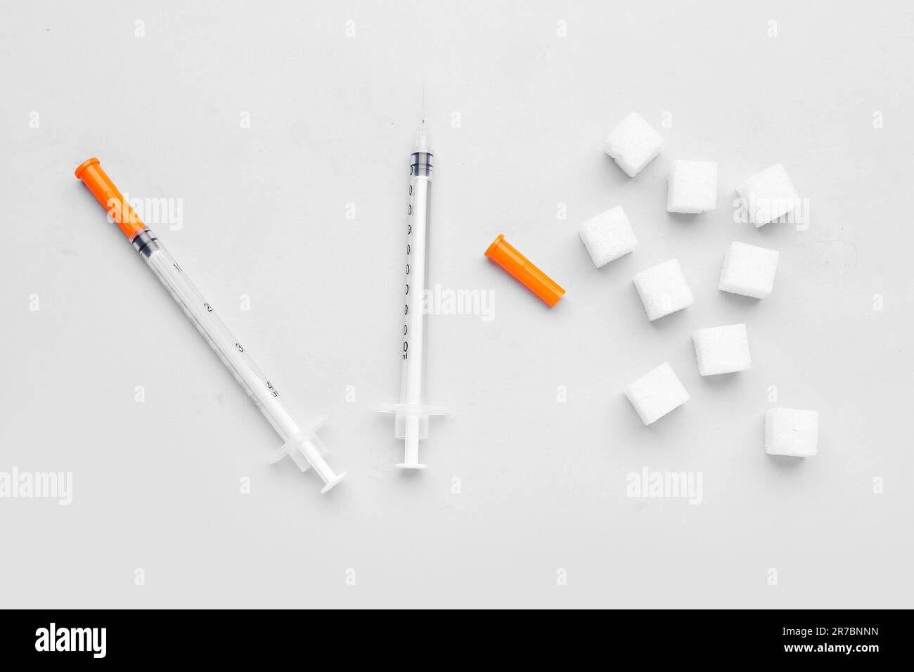 Sugar cubes with syringes for insulin injection on white background ...