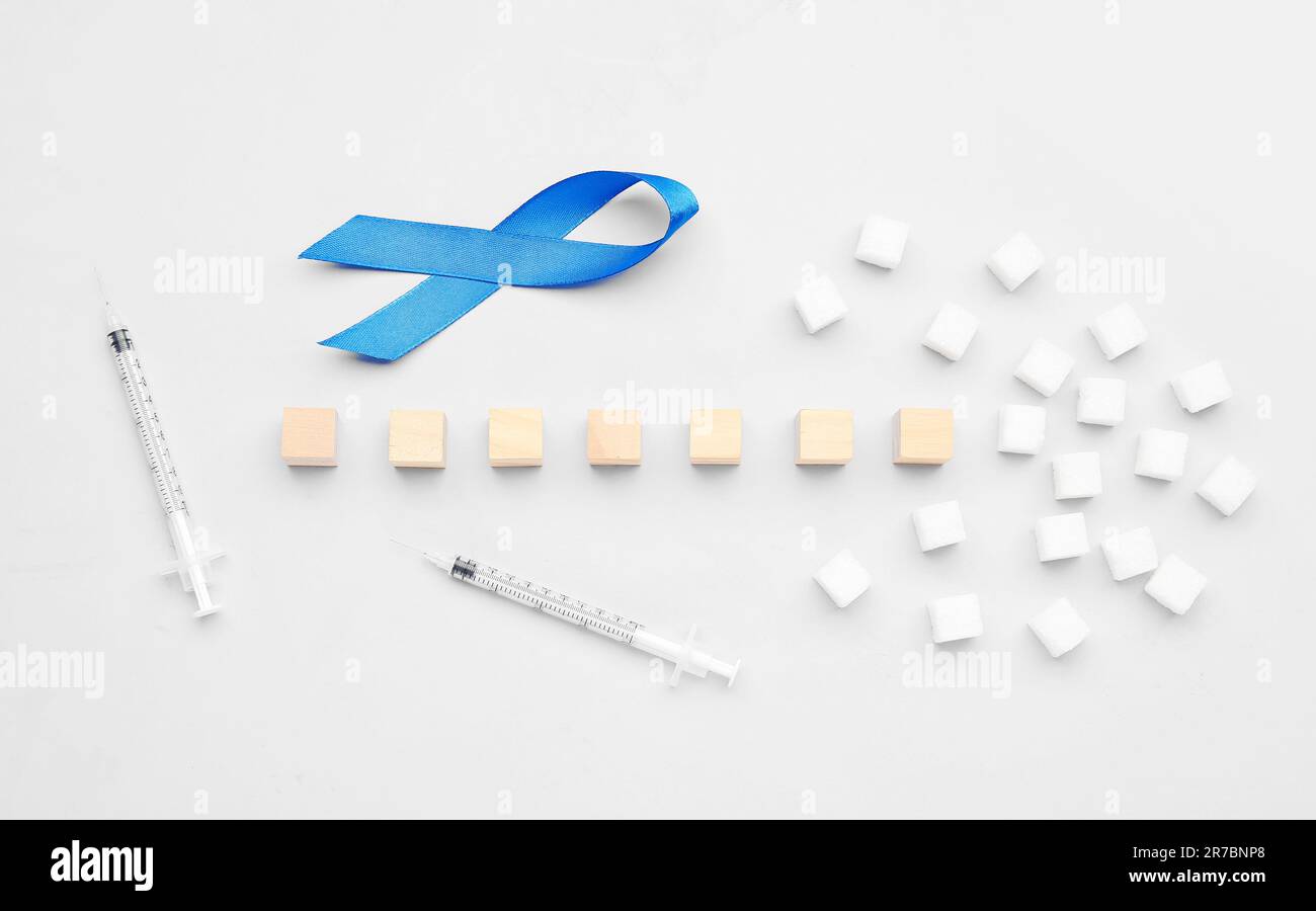 Word INSULIN with awareness ribbon, syringes and sugar cubes on white ...