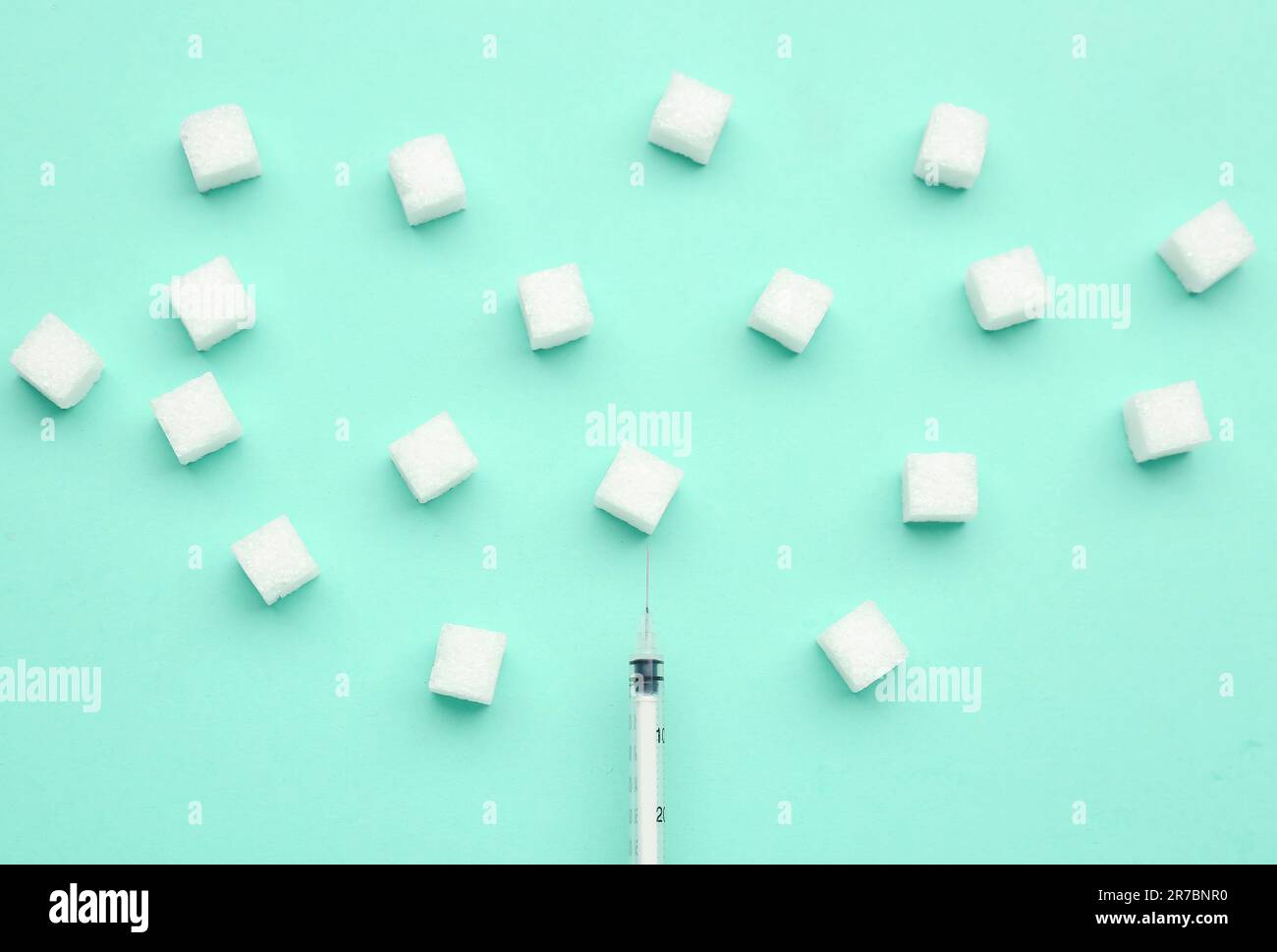 Sugar cubes with syringe for insulin injection on green background ...