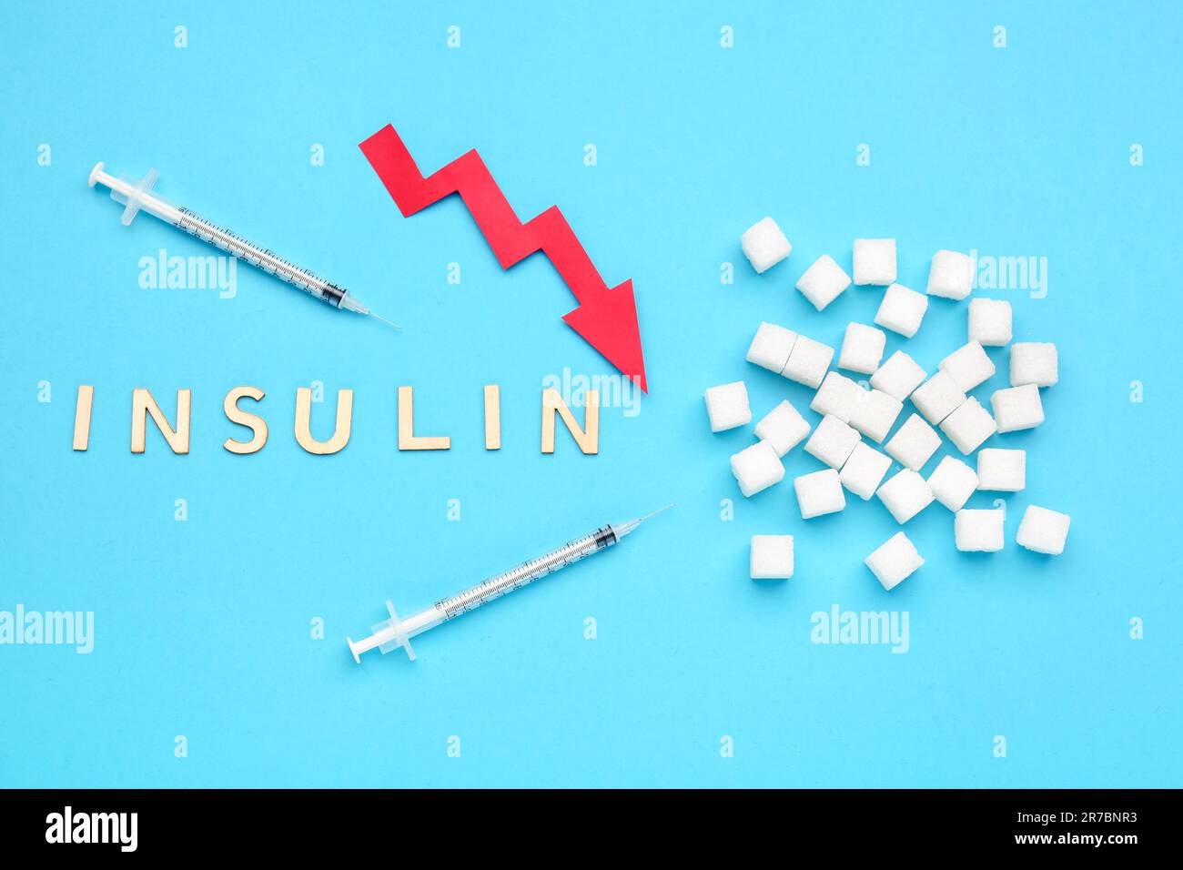 Word INSULIN with syringes, sugar and arrow directed downwards on blue ...