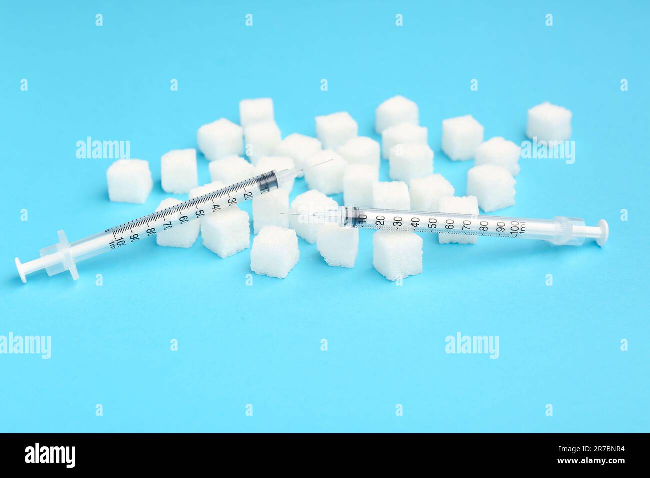 Sugar cubes with syringes for insulin injection on blue background ...
