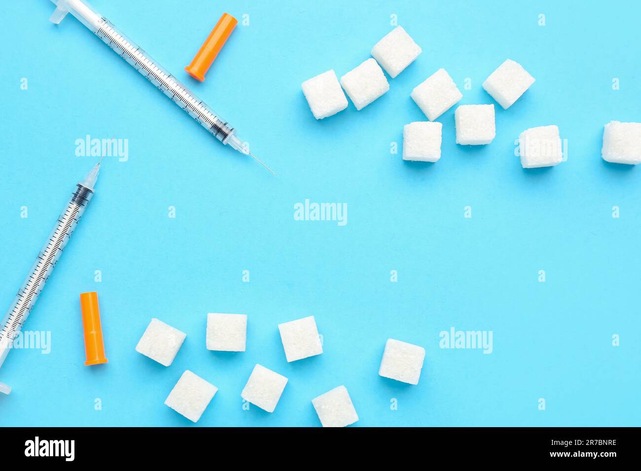 Frame made of sugar with syringes for insulin injection on blue ...