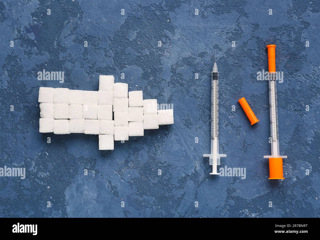 Arrow made of sugar with syringes for insulin injection on dark ...