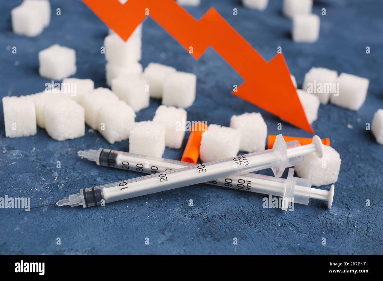 Sugar cubes with syringes for insulin injection on dark background ...