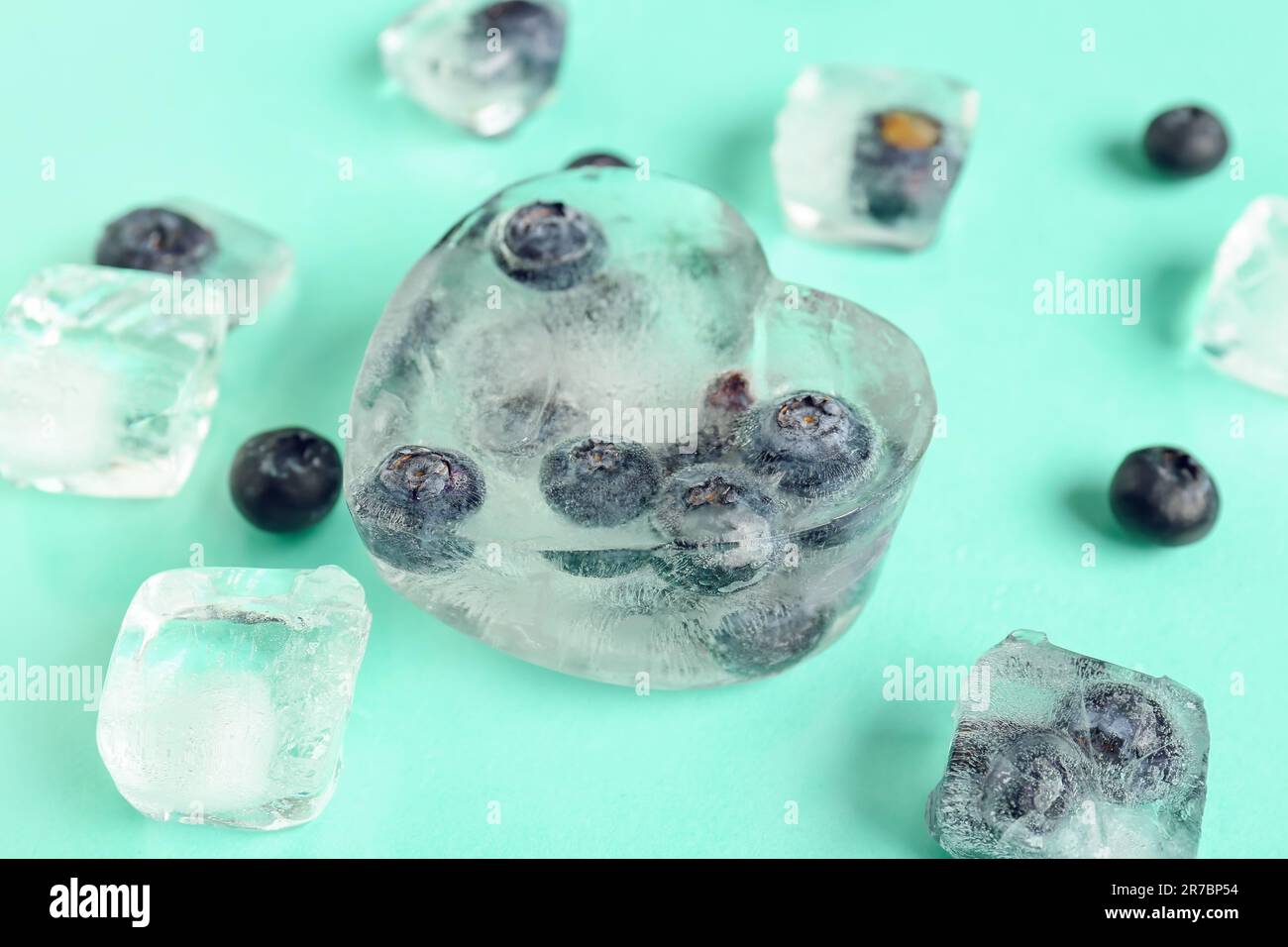 Fresh blueberry frozen in ice on blue background Stock Photo - Alamy