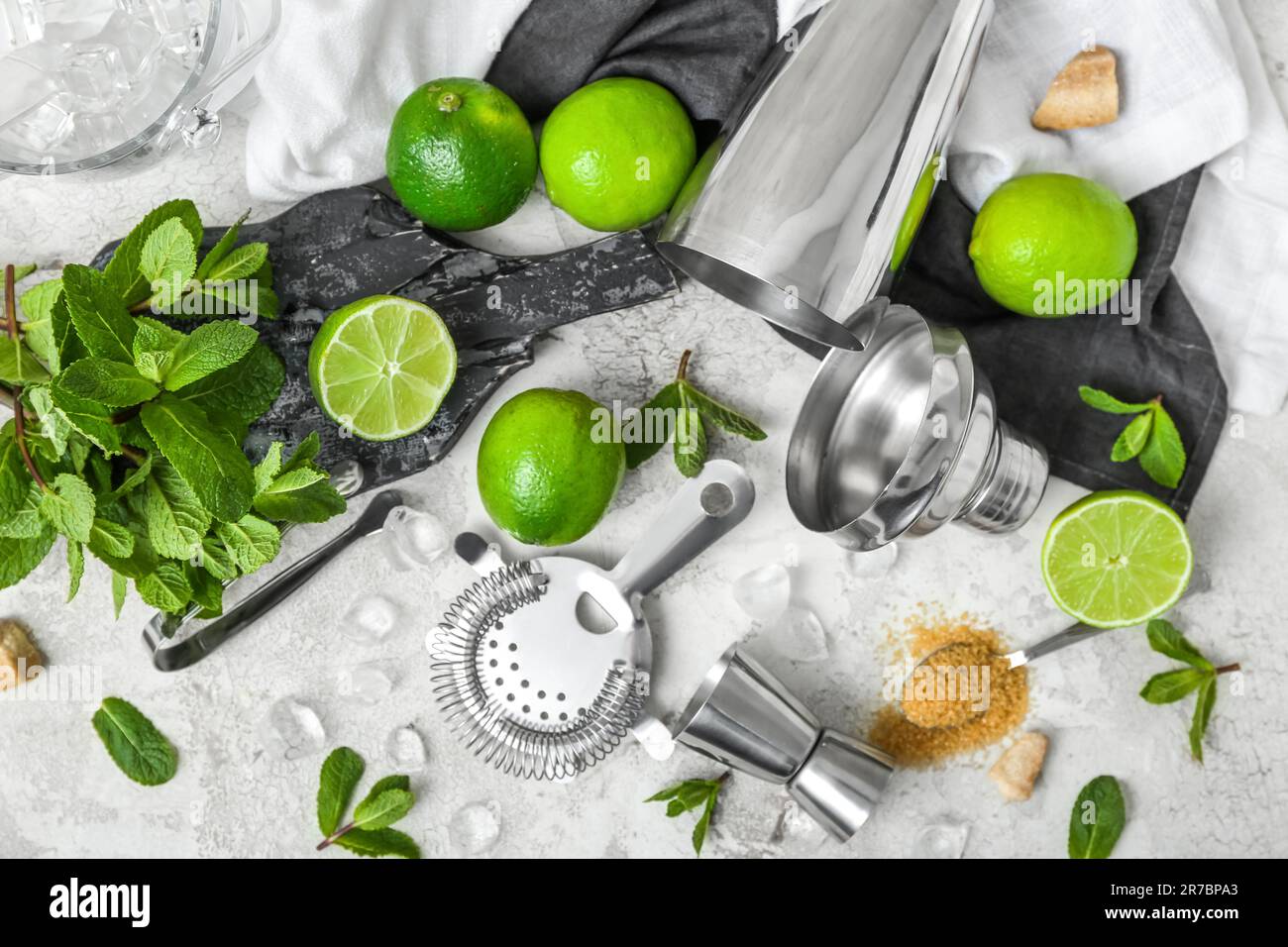 Measure cup, strainer and ingredients for preparing mojito on light ...