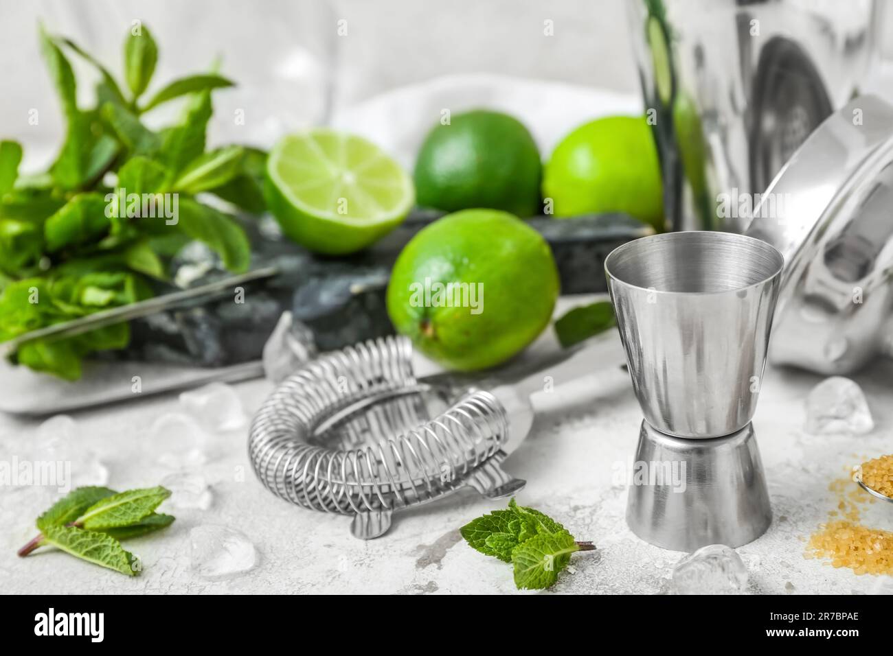 Measure cup and ingredients for preparing mojito on light background Stock Photo - Alamy