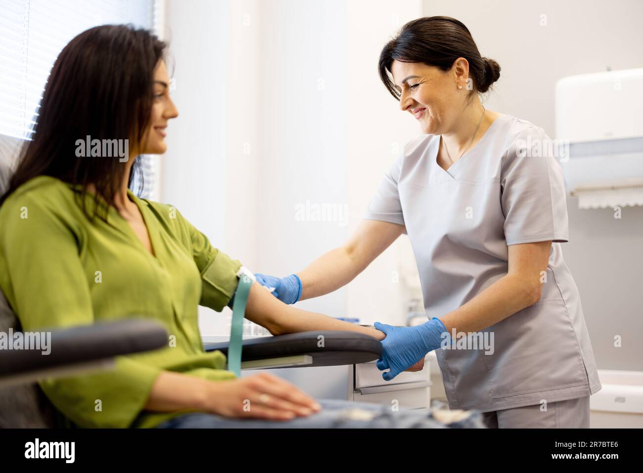 Nurse takes blood test of a young woman in laboratory Stock Photo - Alamy