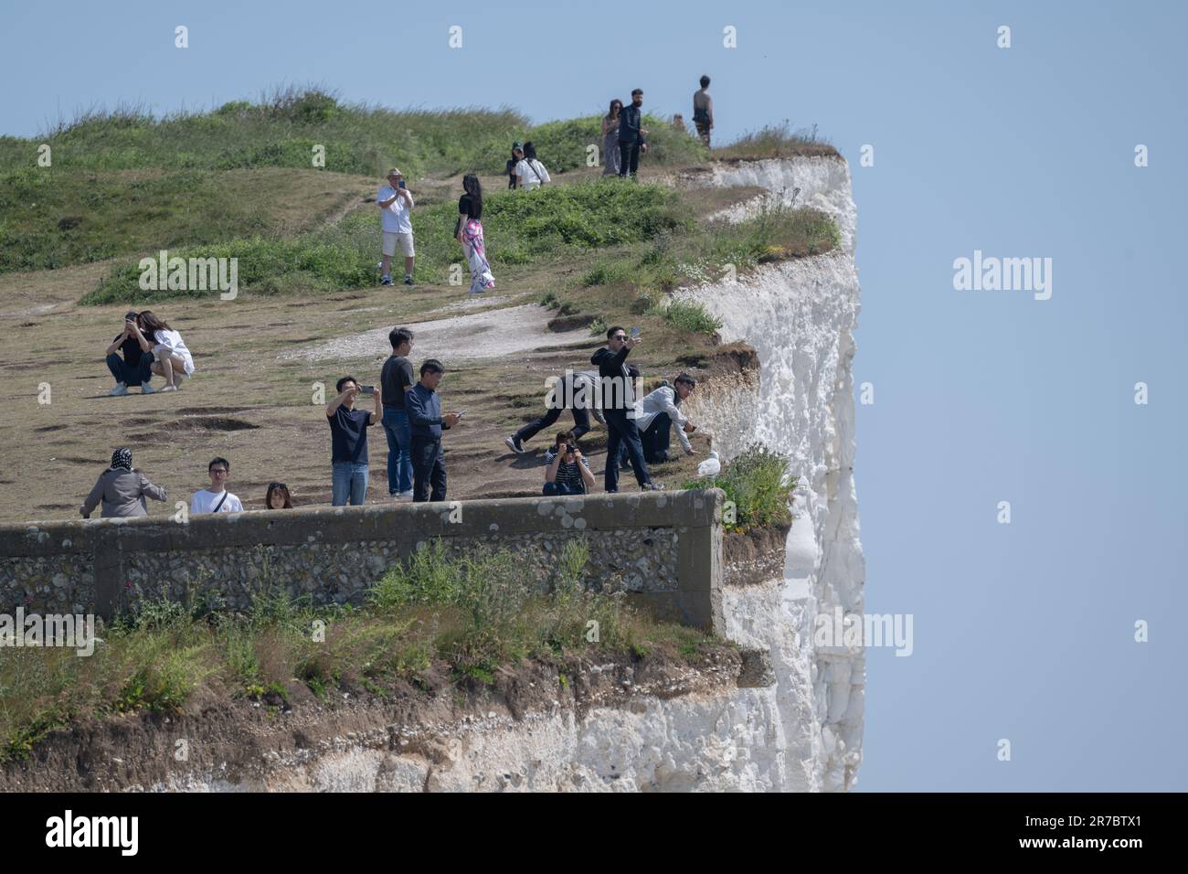 Tourists standing dangerously close to Beachy Head Cliff Edge viewed ...