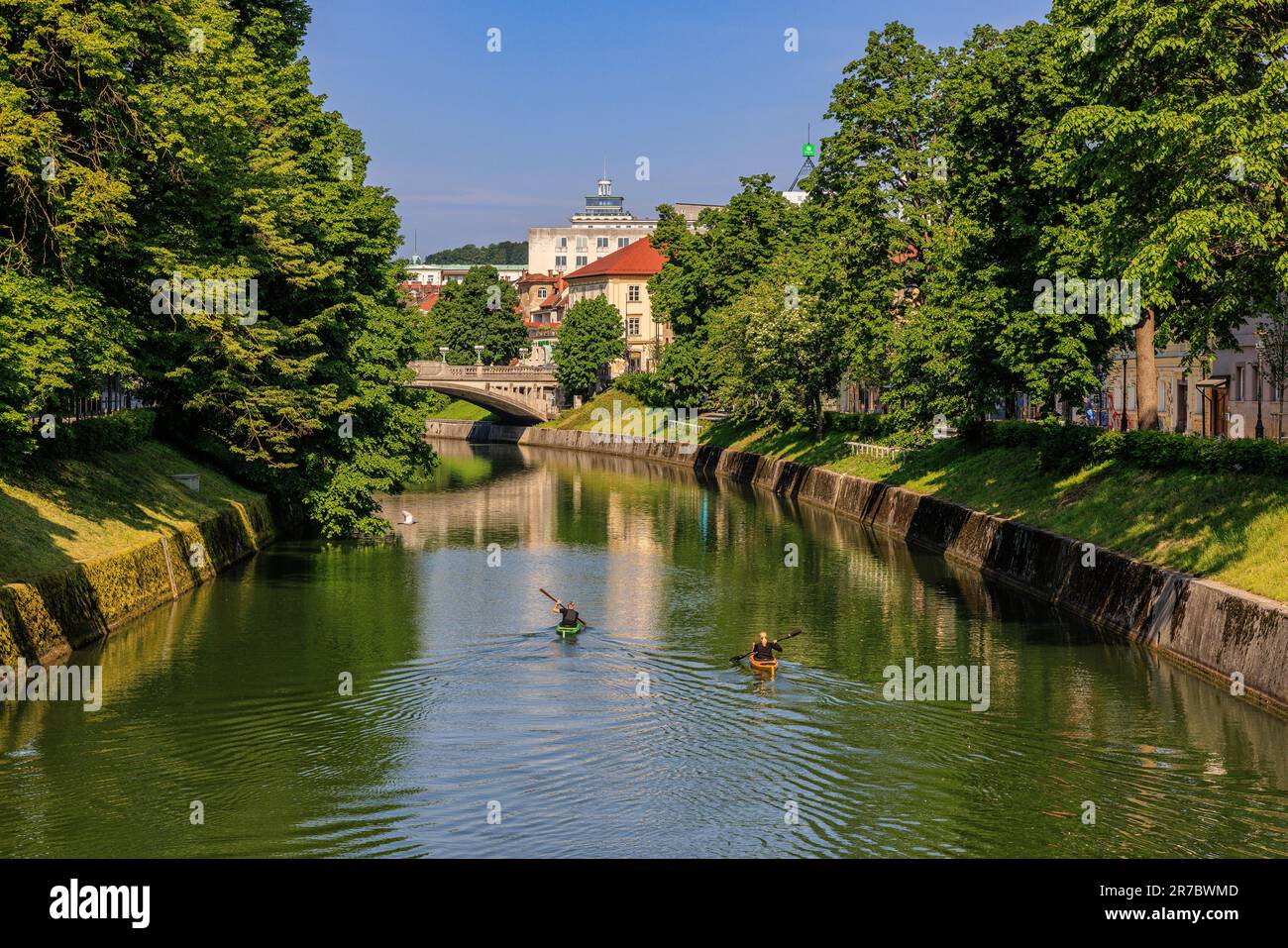 two canoes paddle under the famous dragon bridge in ljubljana arch ...