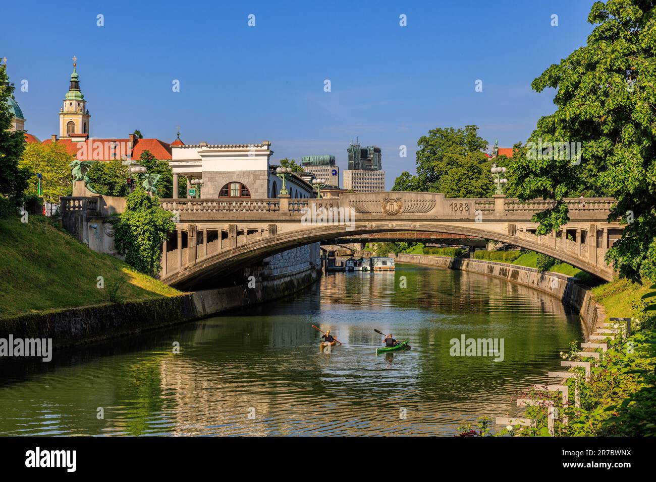 two canoes paddle under the famous dragon bridge in ljubljana arch ...