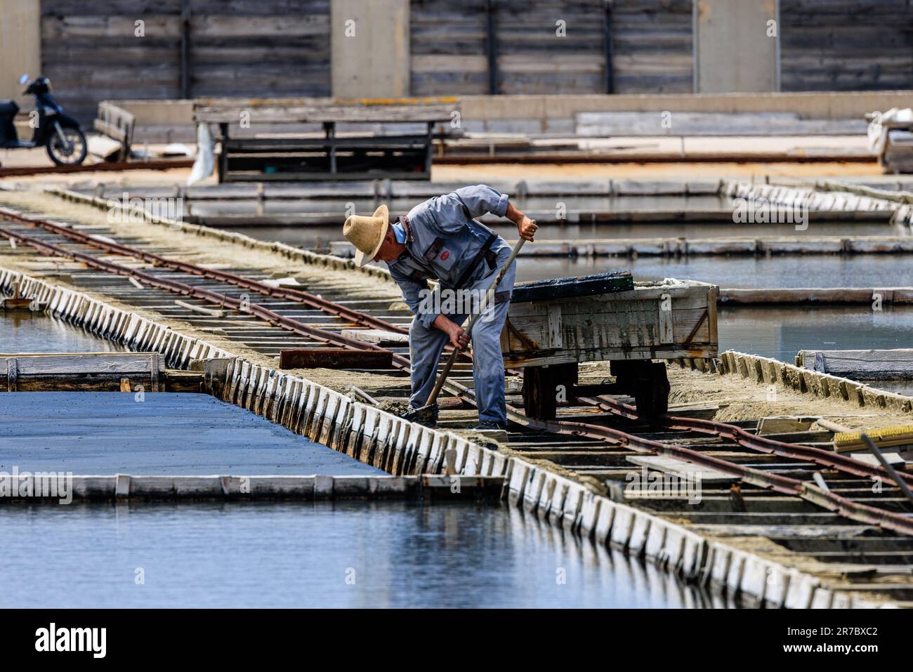 piran salt pans worker in distinctive hat use traditional wooden tools ...