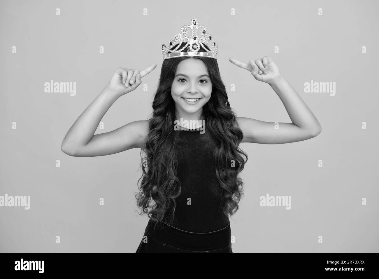Teen child in queen crown isolated on yellow background. Princess girl ...